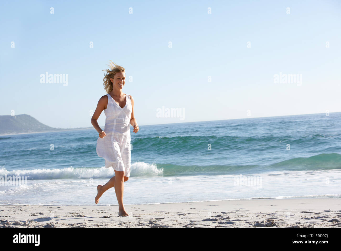 Casually Dressed Young Woman Running Along Beach Stock Photo - Alamy
