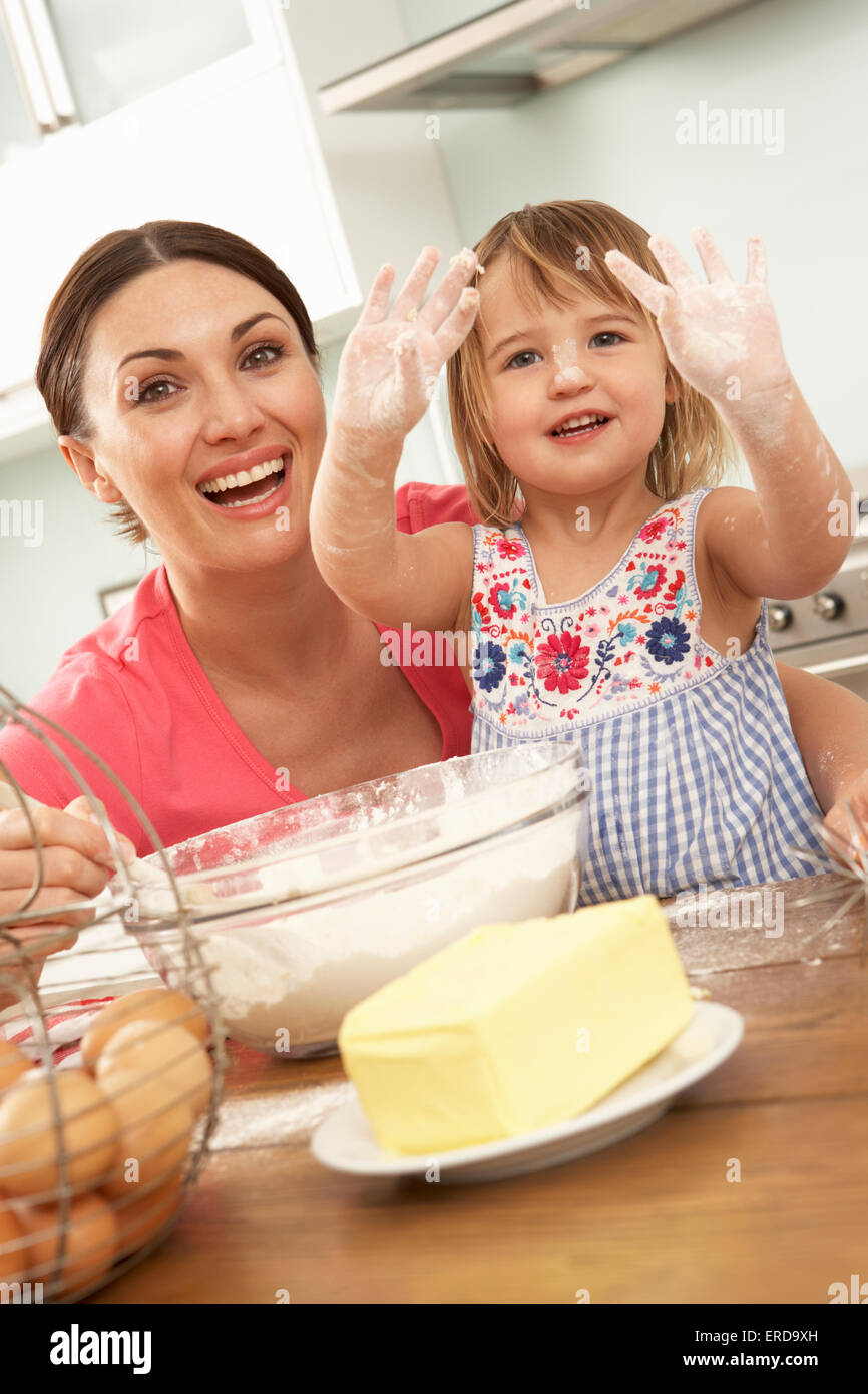 Young Girl Helping Mother To Bake Cakes In Kitchen Stock Photo - Alamy