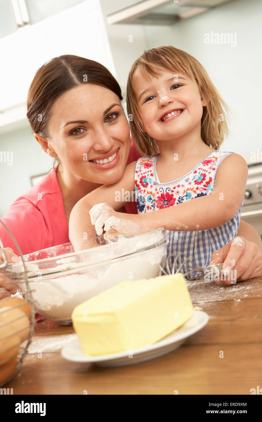 Young Girl Helping Mother To Bake Cakes In Kitchen Stock Photo - Alamy