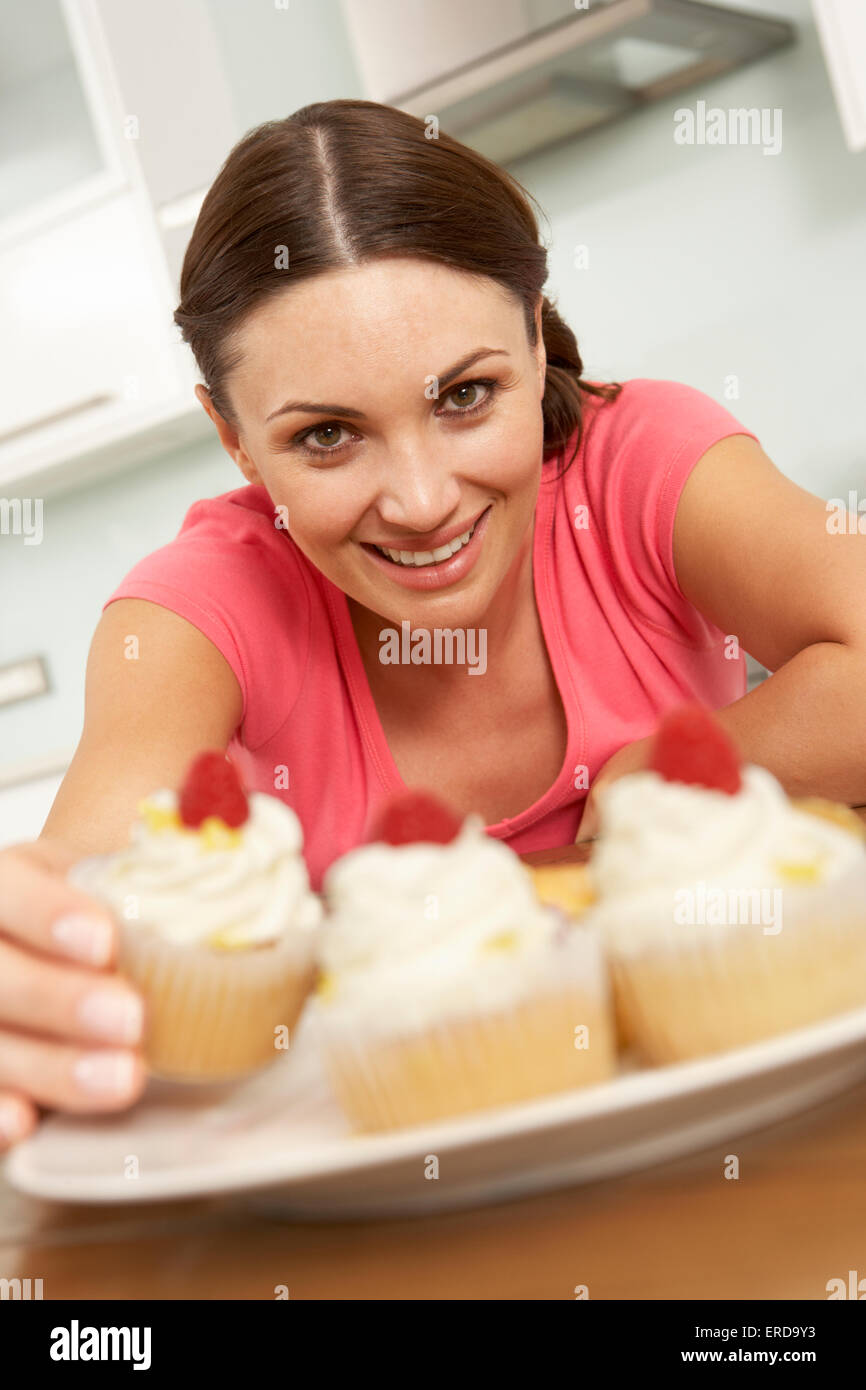 Woman Eating Cakes In Kitchen Stock Photo - Alamy