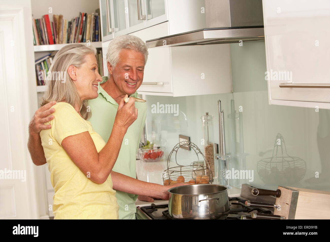 Senior Couple Preparing Meal At Cooker Stock Photo - Alamy