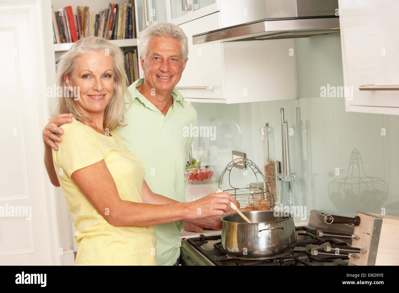 Senior Couple Preparing Meal At Cooker Stock Photo - Alamy