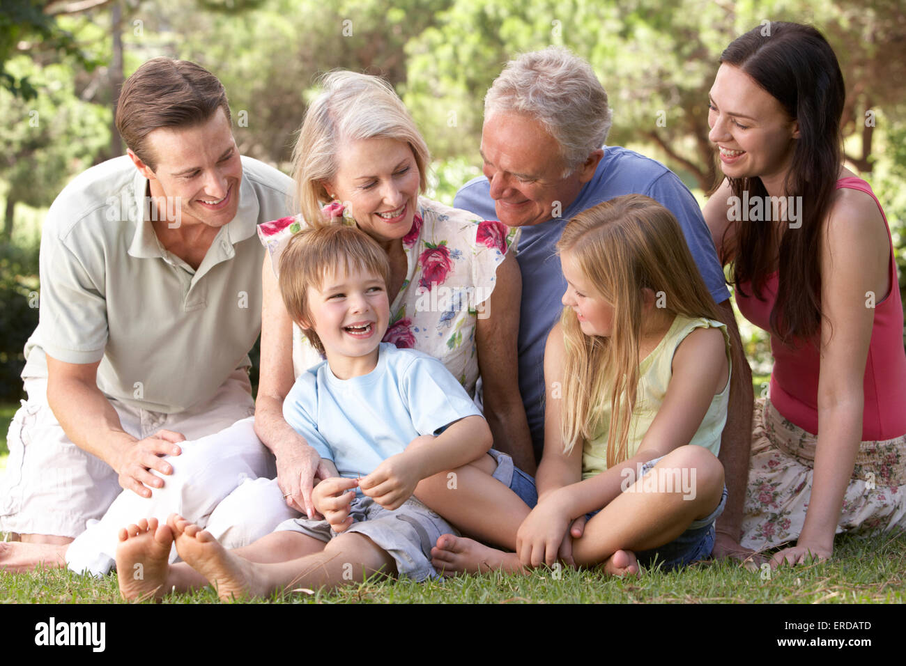 Three Generation Family Sitting In Park Together Stock Photo - Alamy