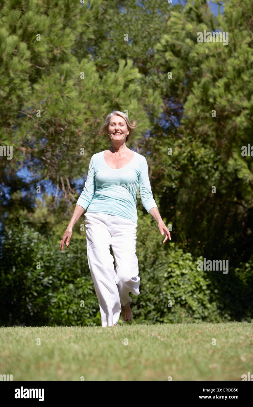 Senior Woman Running Through Summer Field Stock Photo - Alamy