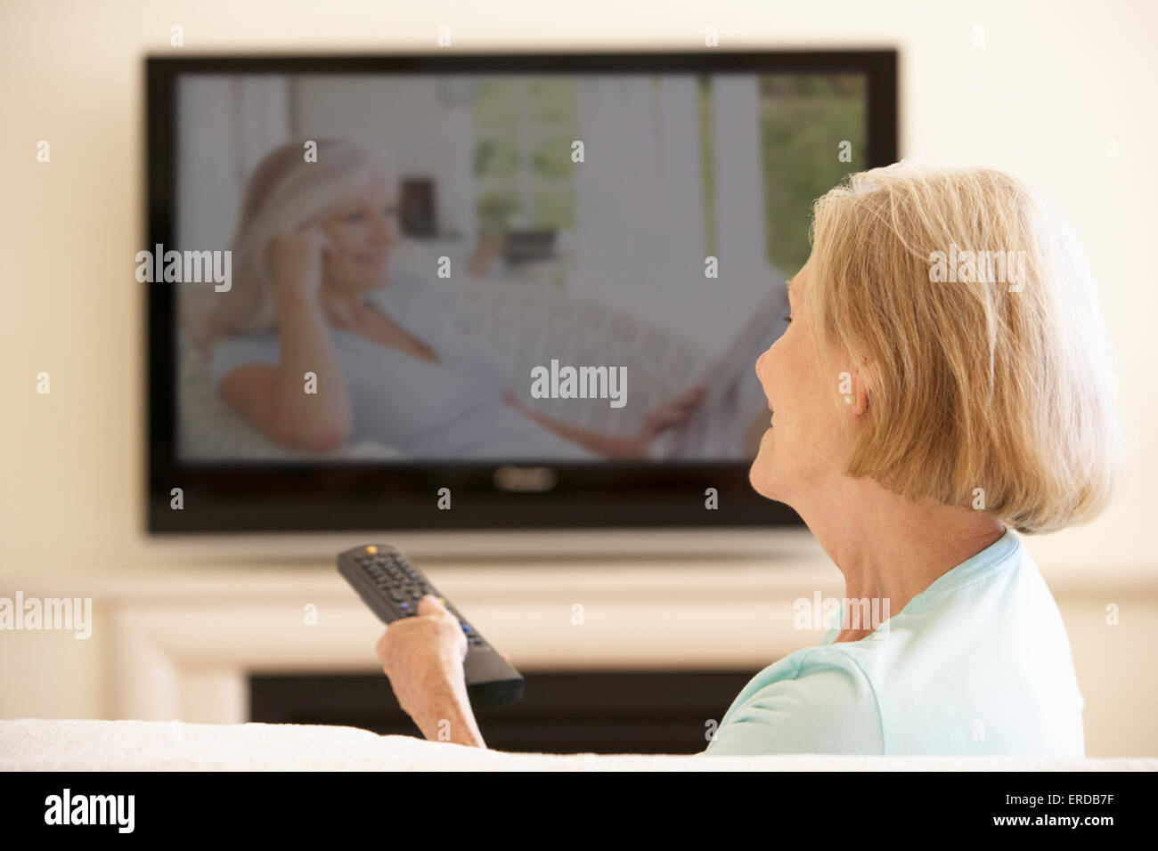 Senior Woman Watching Widescreen TV At Home Stock Photo - Alamy