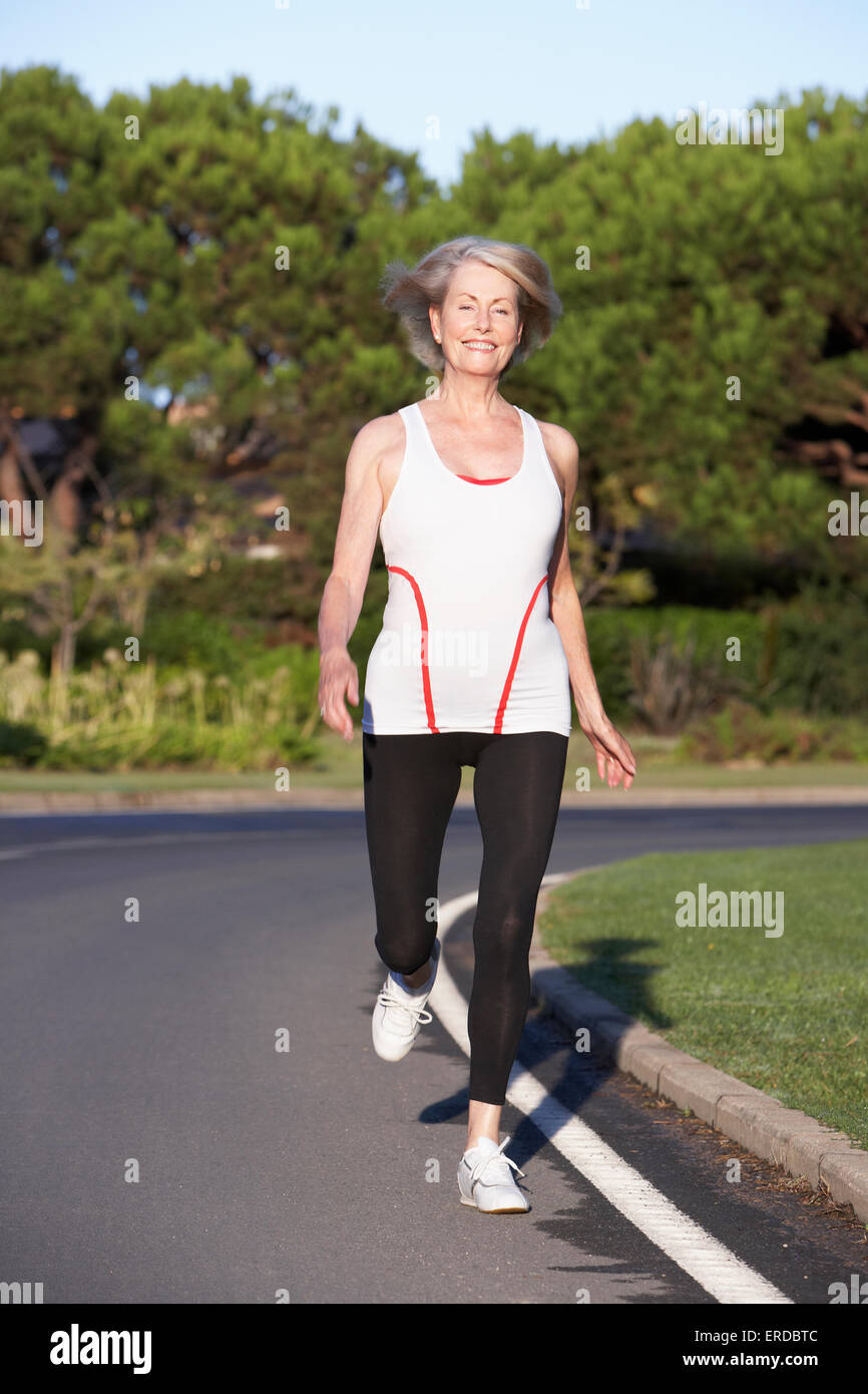 Senior Woman Running On Road Stock Photo - Alamy