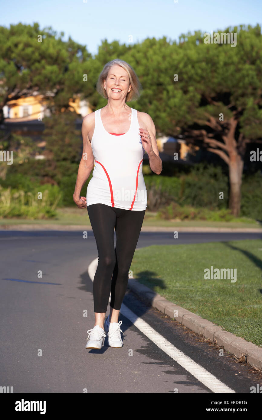 Senior Woman Running On Road Stock Photo - Alamy