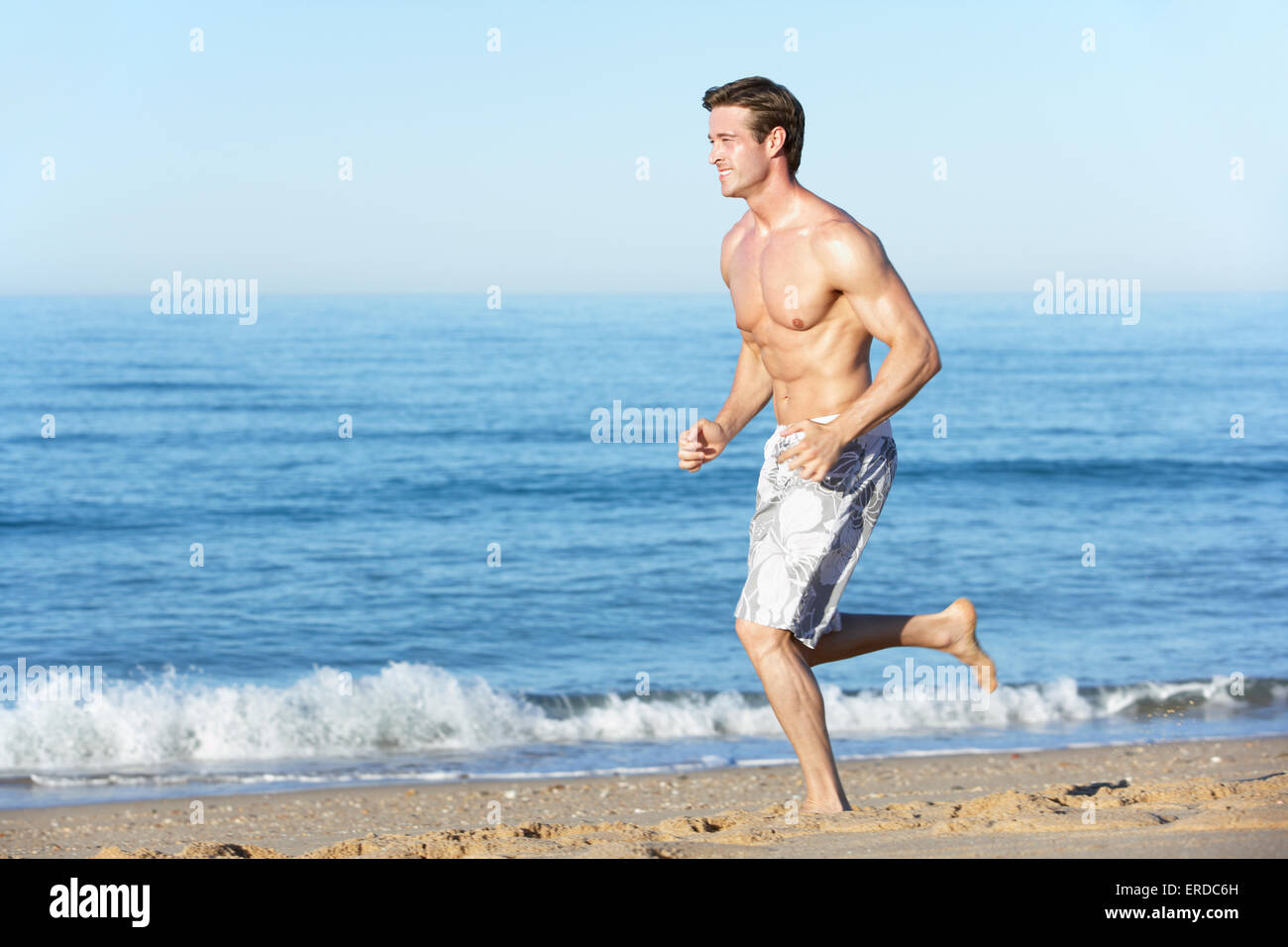Young Man Running Along Summer Beach Stock Photo - Alamy