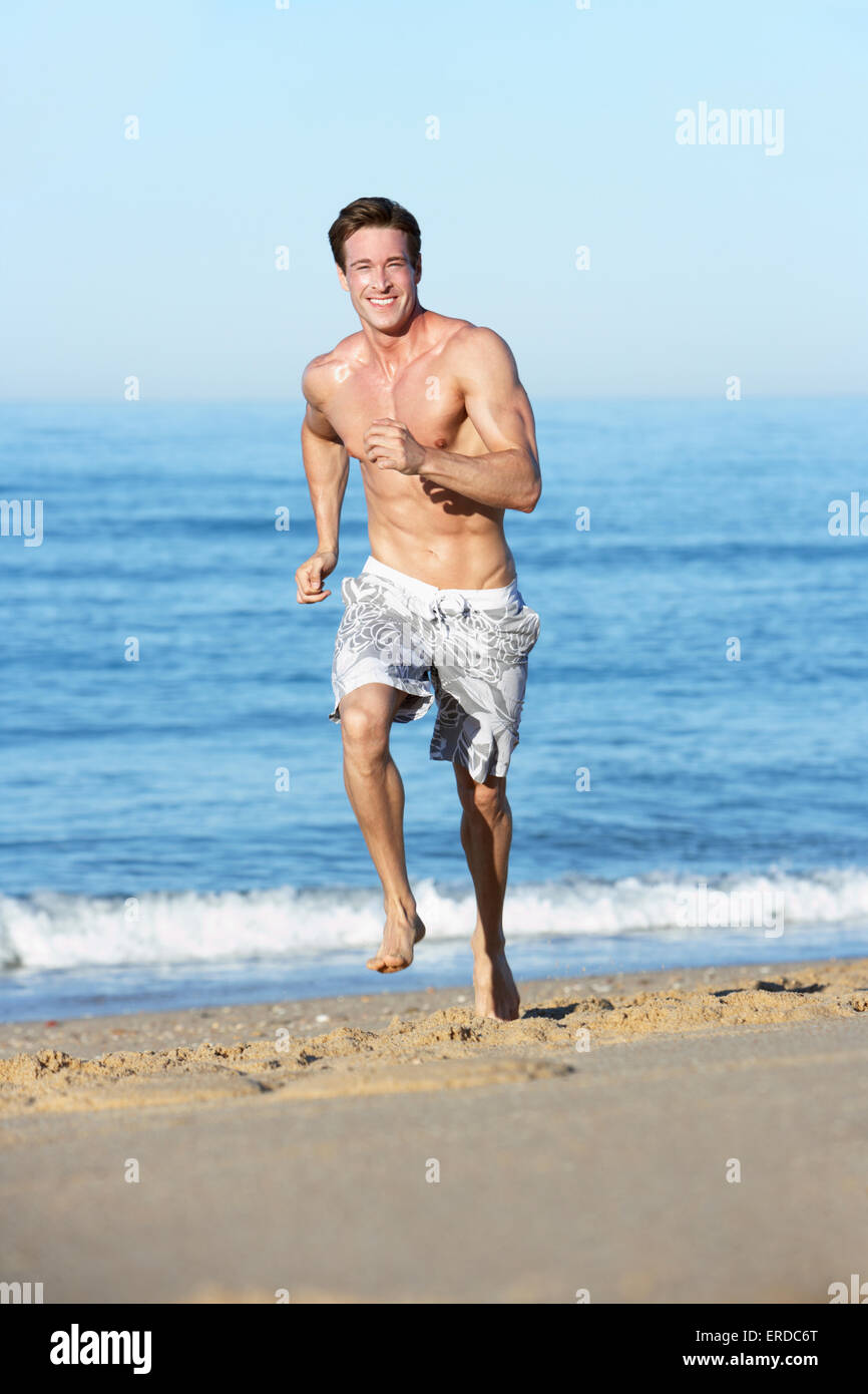 Young Man Running Along Summer Beach Stock Photo - Alamy