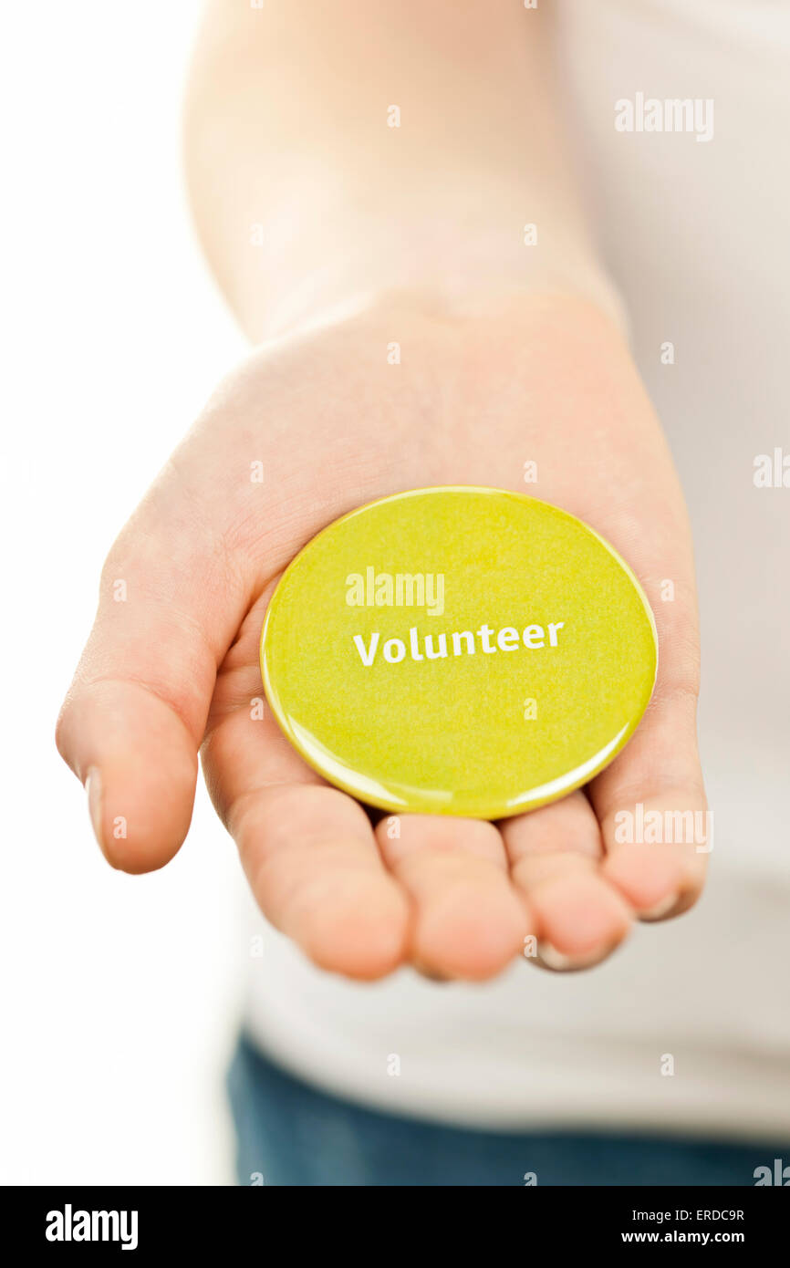 Closeup on female hand holding green volunteer button Stock Photo - Alamy