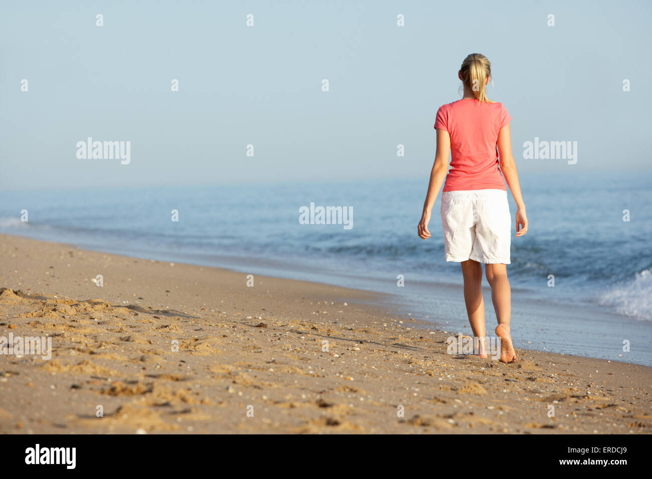 Woman Walking Along Beach Stock Photo - Alamy