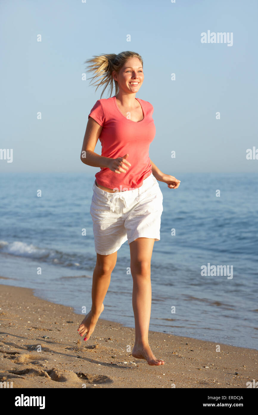 Woman Running Along Beach Stock Photo - Alamy