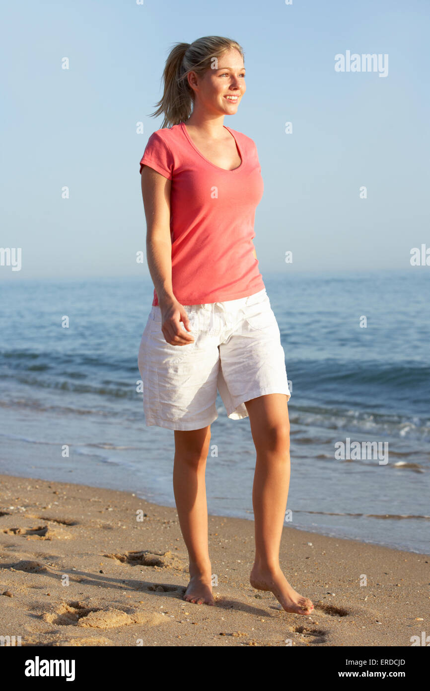 Woman Walking Along Beach Stock Photo - Alamy