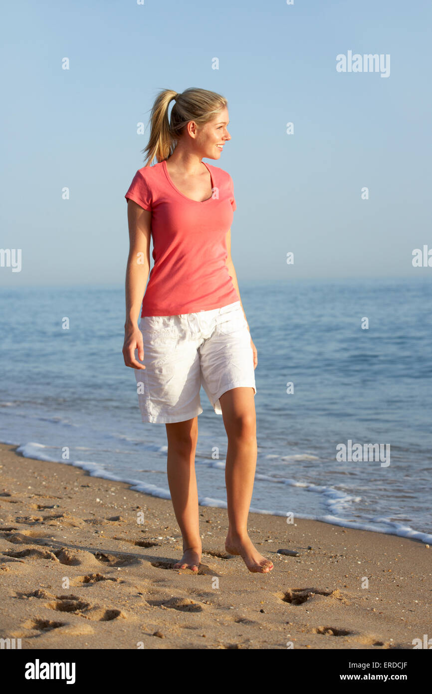 Woman Walking Along Beach Stock Photo - Alamy