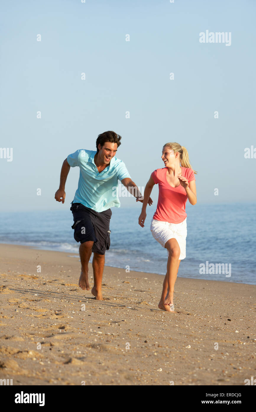 Caucasian couple running on beach hi-res stock photography and images ...