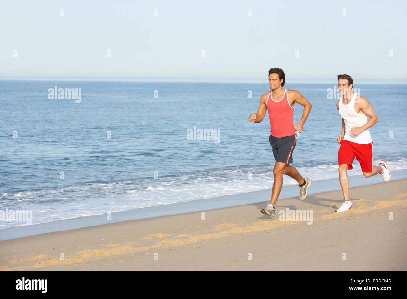 Fit young men jogging along beach hi-res stock photography and images ...