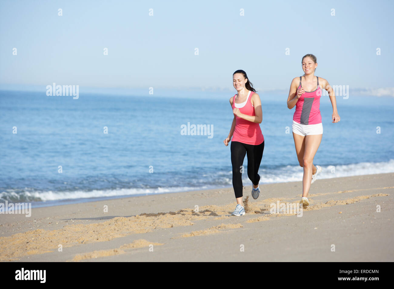 Two women jogging along beach hi-res stock photography and images - Alamy