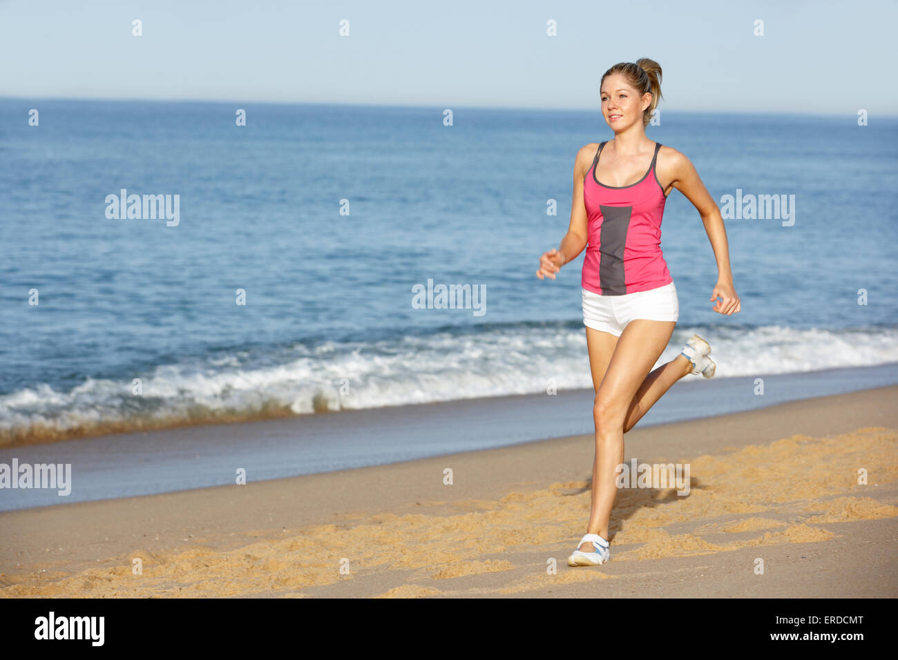 Young Woman Jogging Along Beach Stock Photo - Alamy