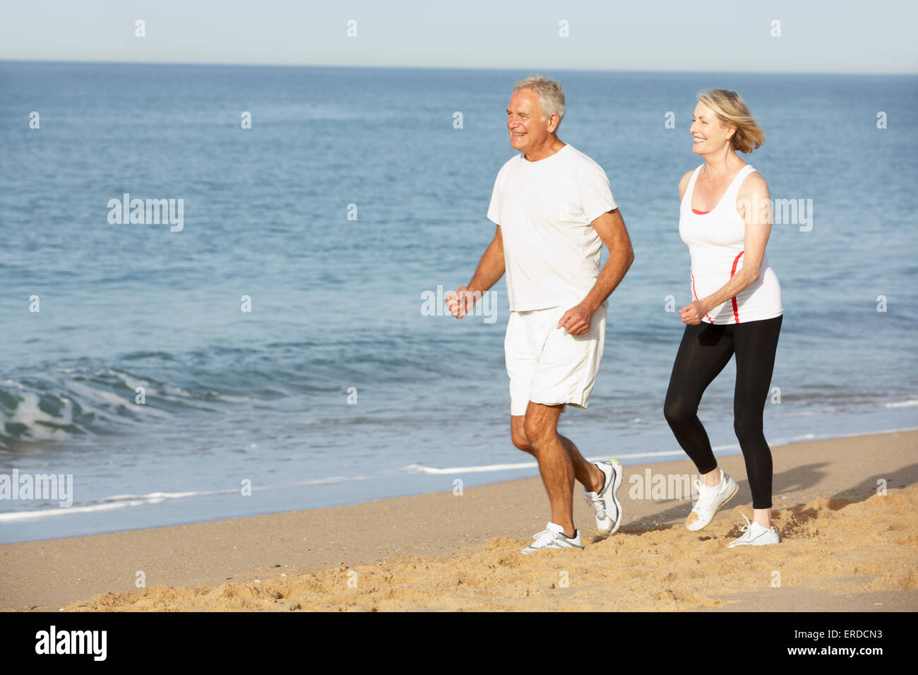 Senior Couple Jogging Along Beach Stock Photo - Alamy