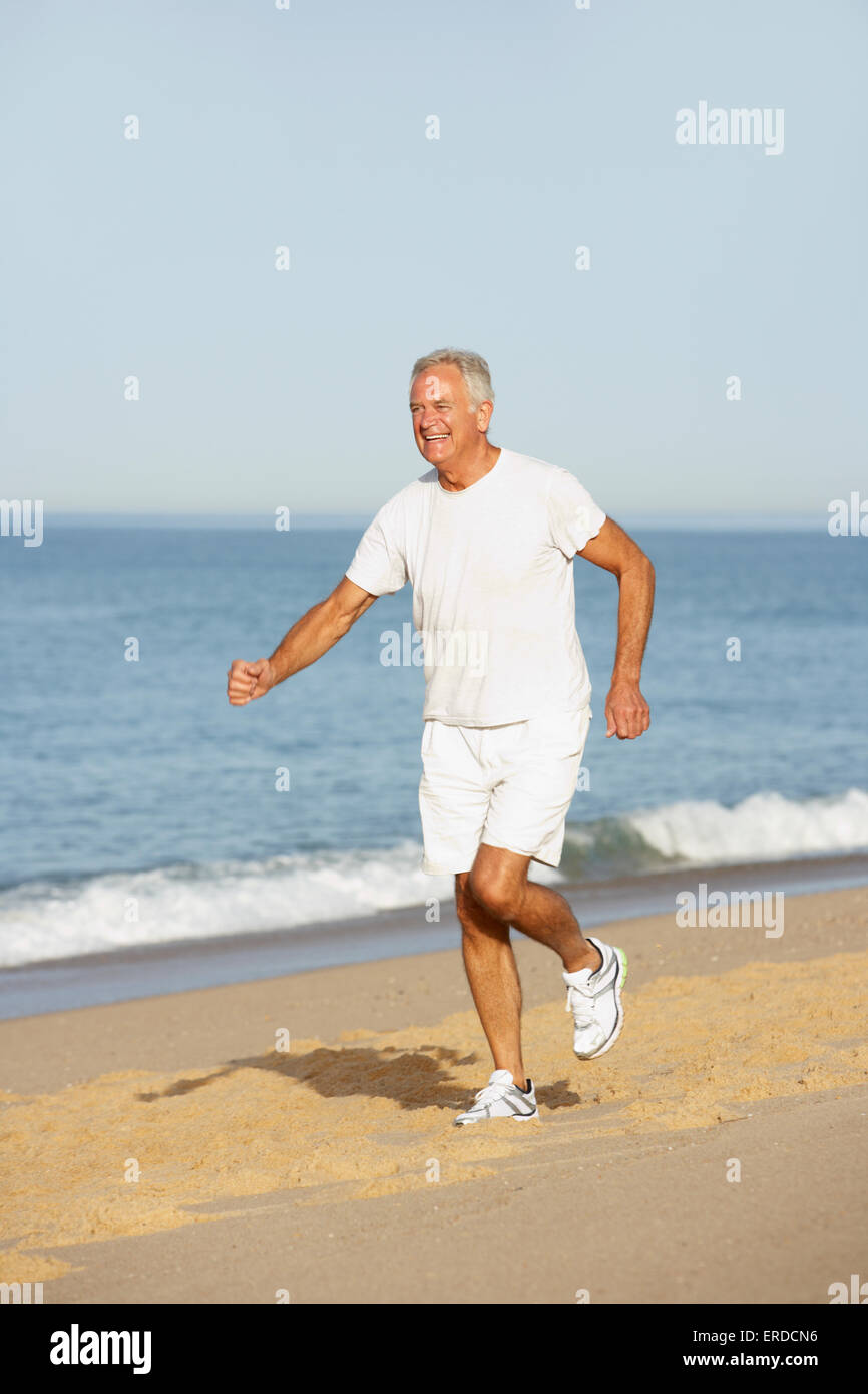 Senior Man Jogging Along Beach Stock Photo - Alamy