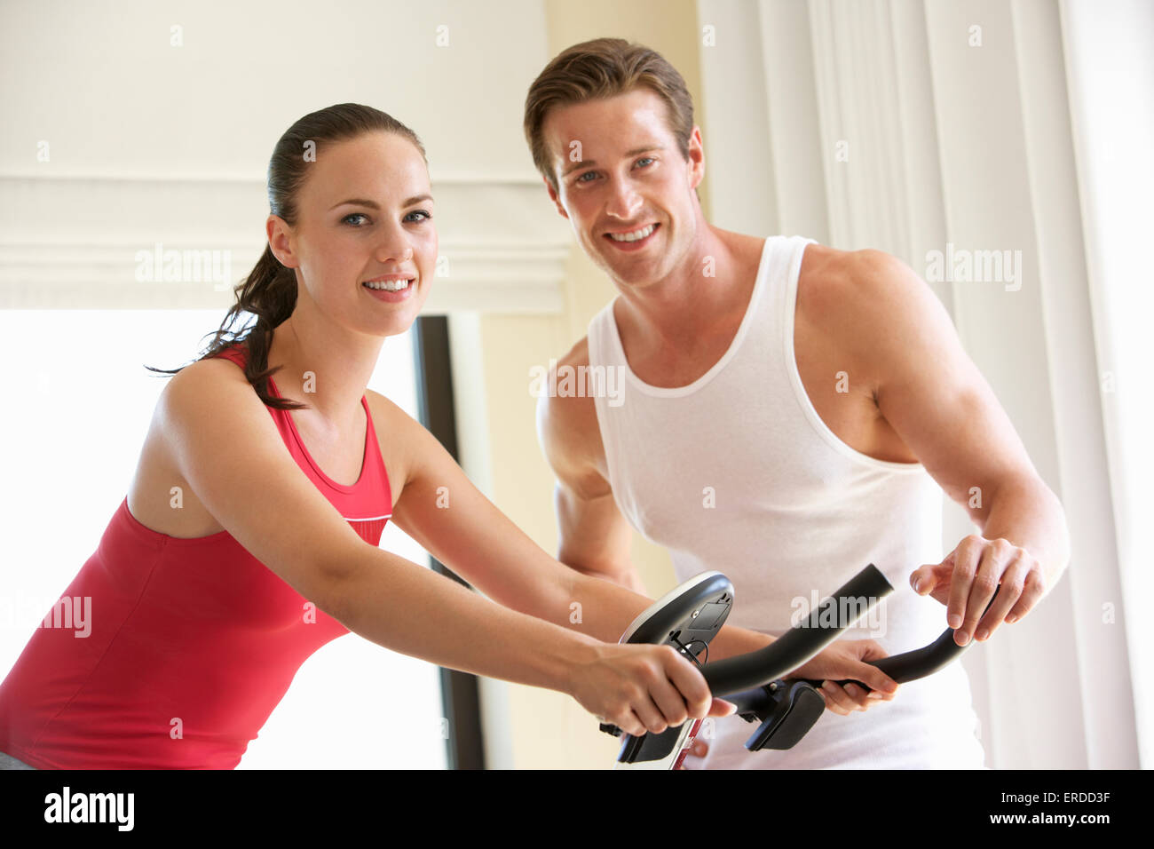 Young Couple On Exercise Bike Stock Photo - Alamy