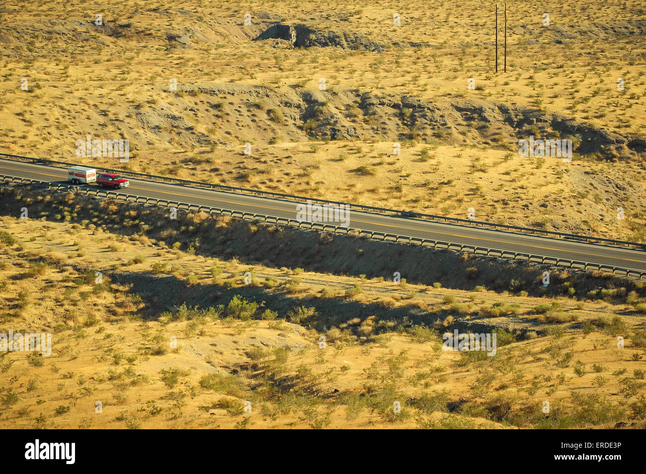 A semi truck drives across the open desert Stock Photo - Alamy