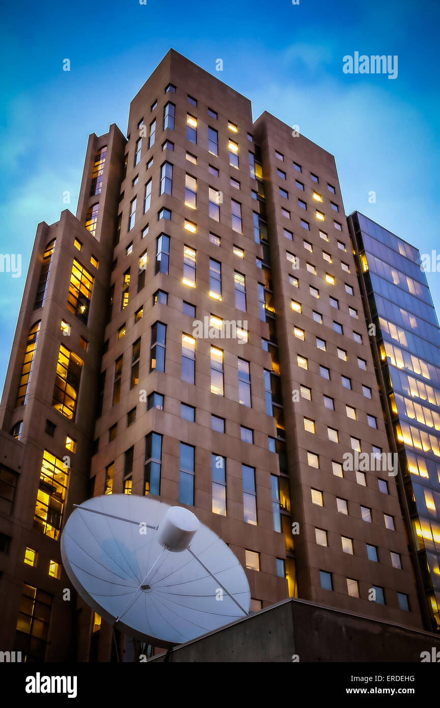 A corporate communications type building with satellite dish at dusk ...