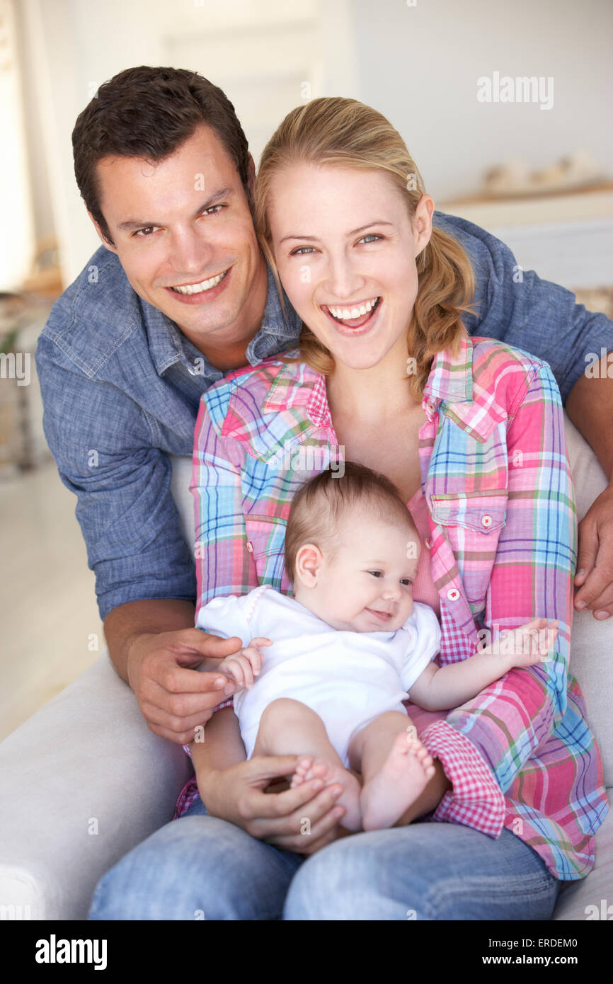 Young Family With Baby Relaxing On Sofa At Home Stock Photo - Alamy