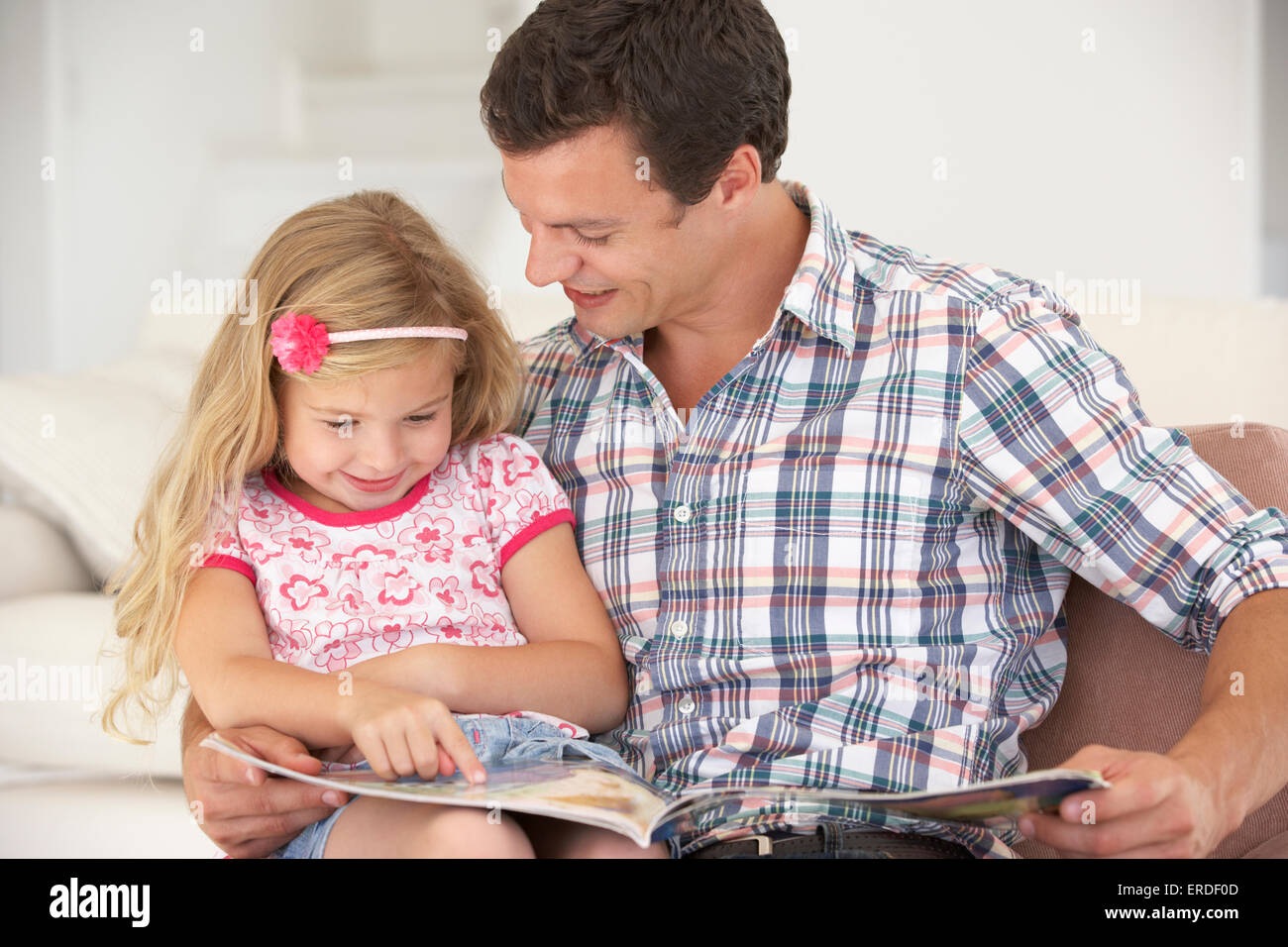 Father And Daughter Reading Book At Home Stock Photo - Alamy