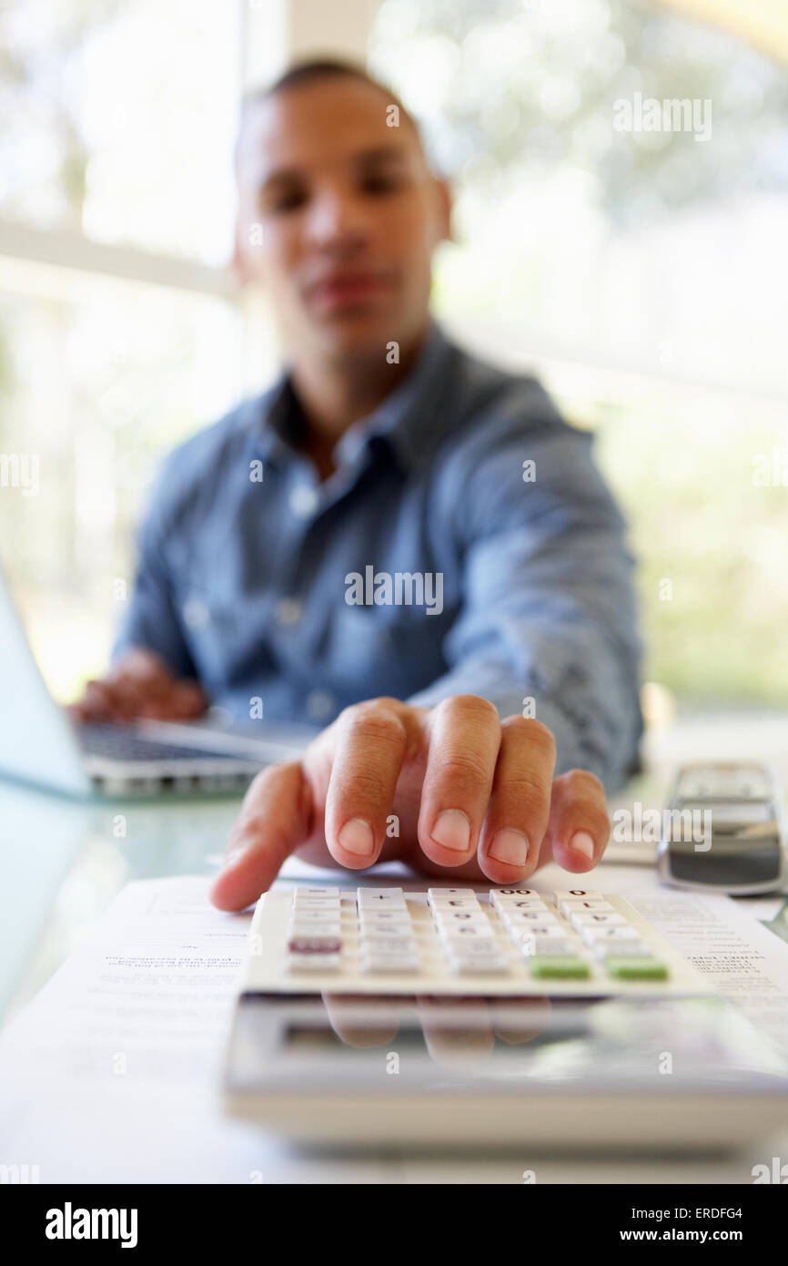 Young Man On Using Calculator At Home Stock Photo - Alamy