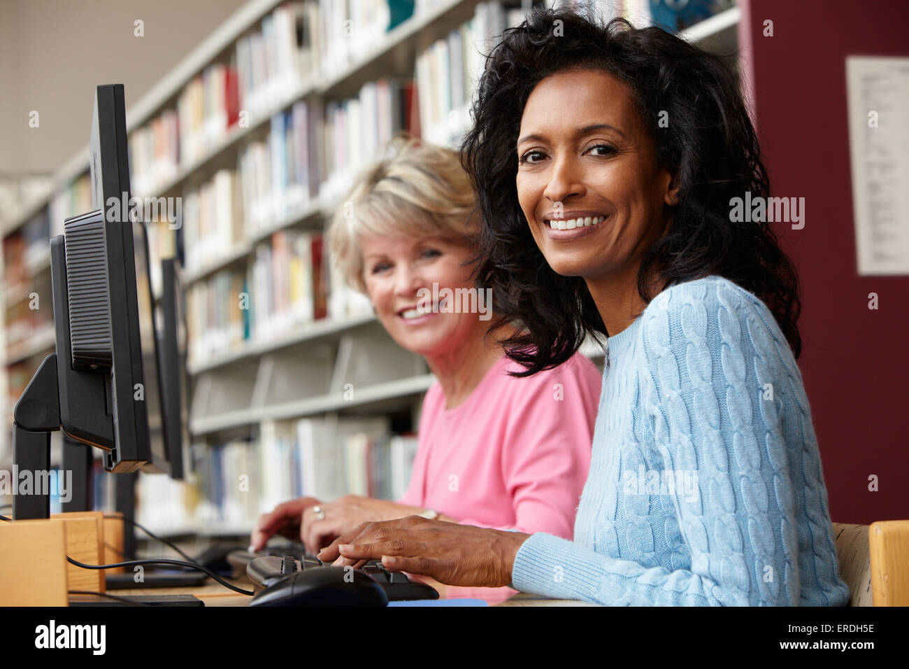 Women working on computers in library Stock Photo - Alamy