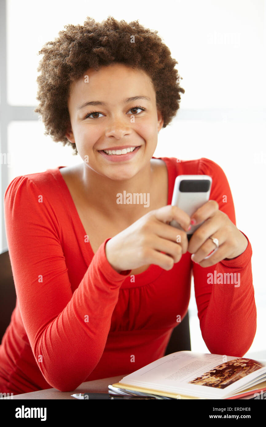 Teenage girl with phone in class Stock Photo - Alamy