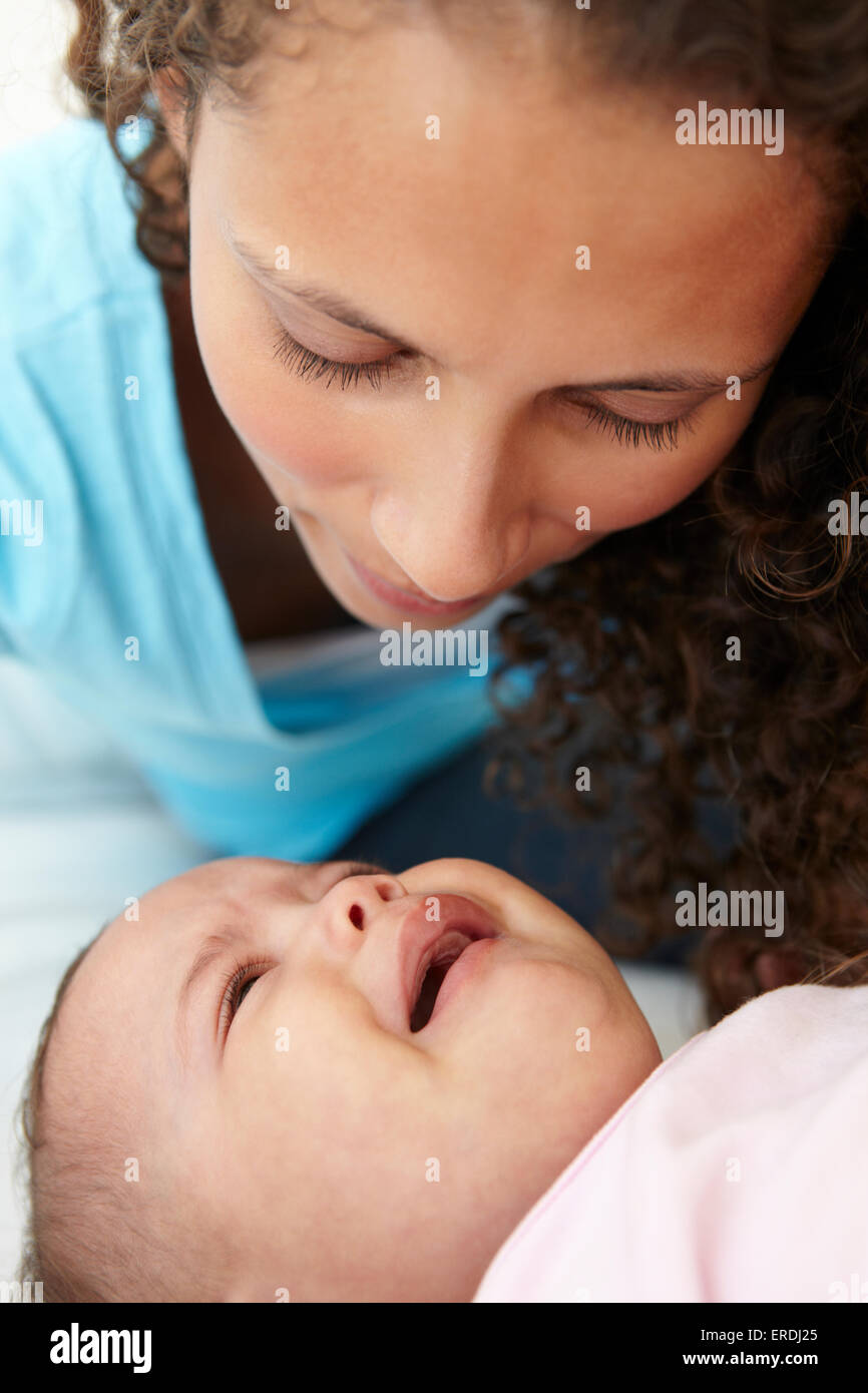 Worried Mother At Home With Crying Baby Stock Photo - Alamy