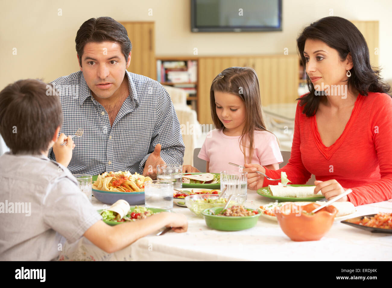 Young Hispanic Family Enjoying Meal At Home Stock Photo - Alamy