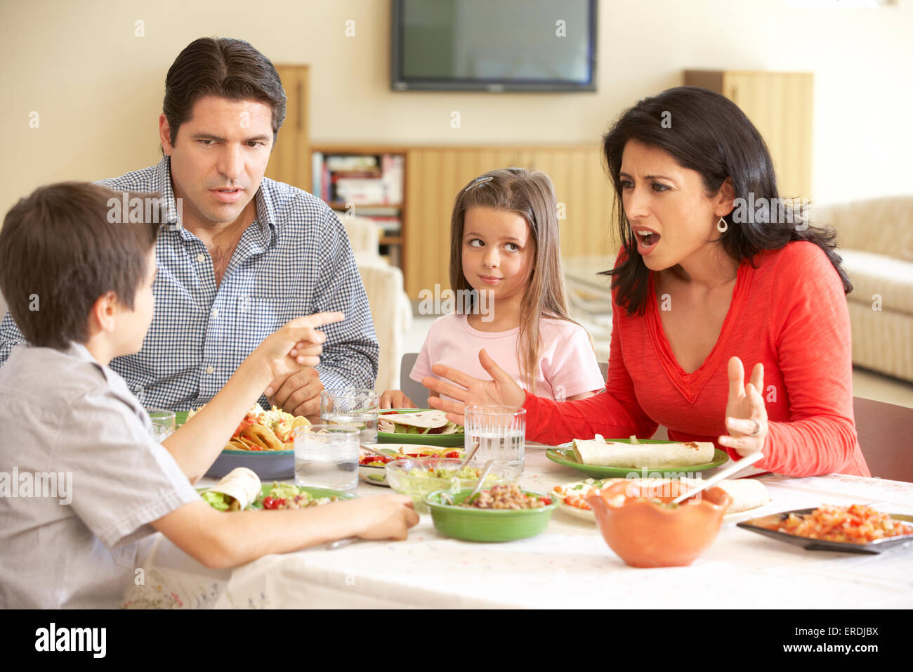Young Hispanic Family Enjoying Meal At Home Stock Photo - Alamy