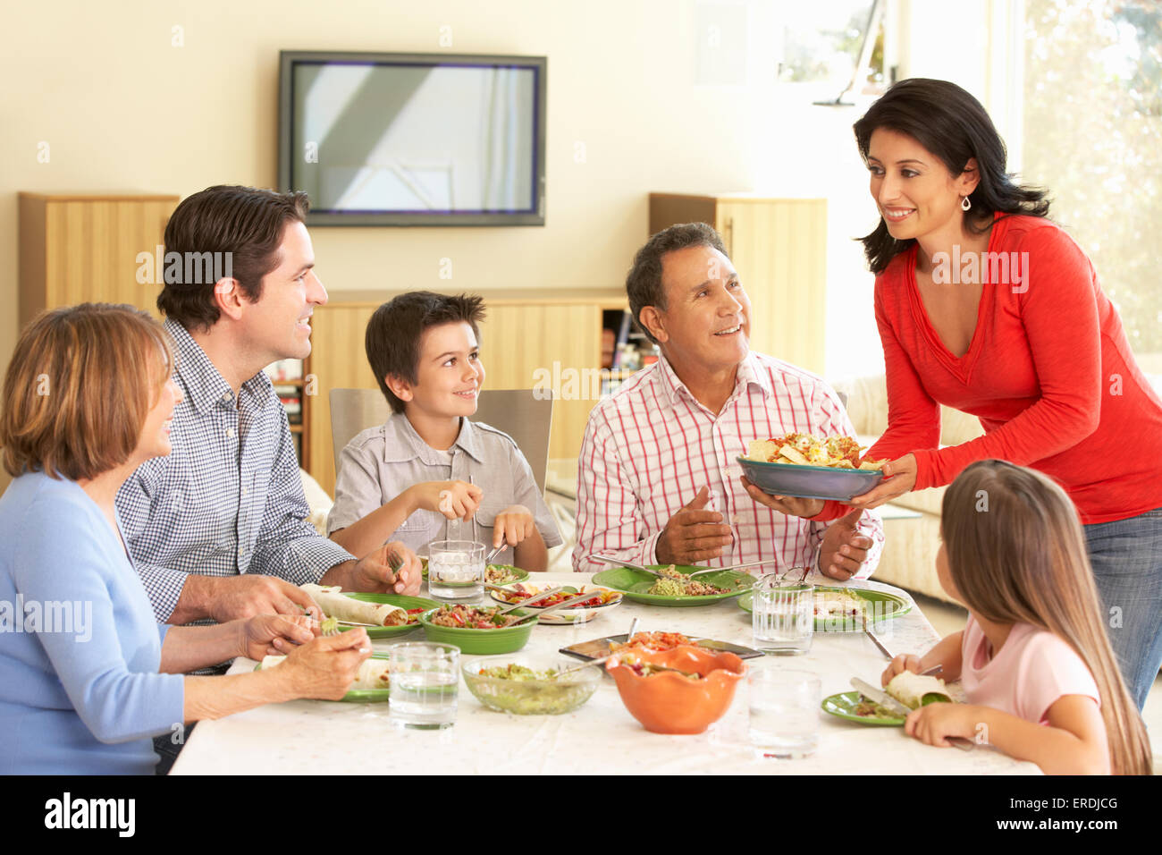 Extended Hispanic Family Enjoying Meal At Home Stock Photo - Alamy