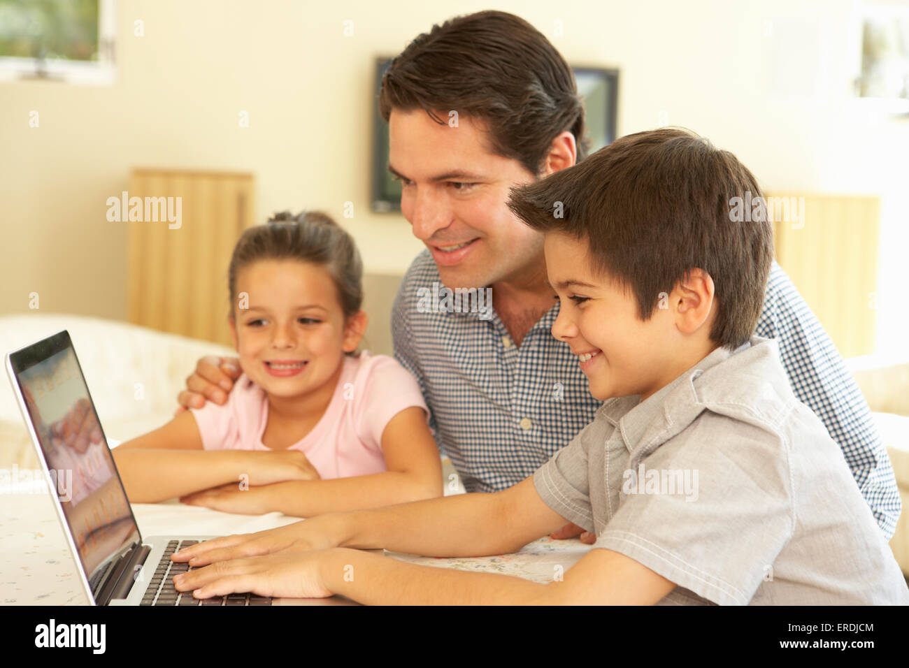 Hispanic Father And Children Using Computer At Home Stock Photo - Alamy
