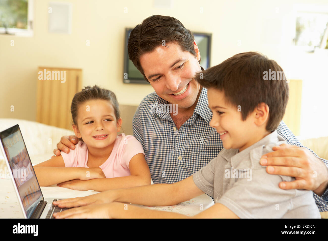 Hispanic Father And Children Using Computer At Home Stock Photo - Alamy