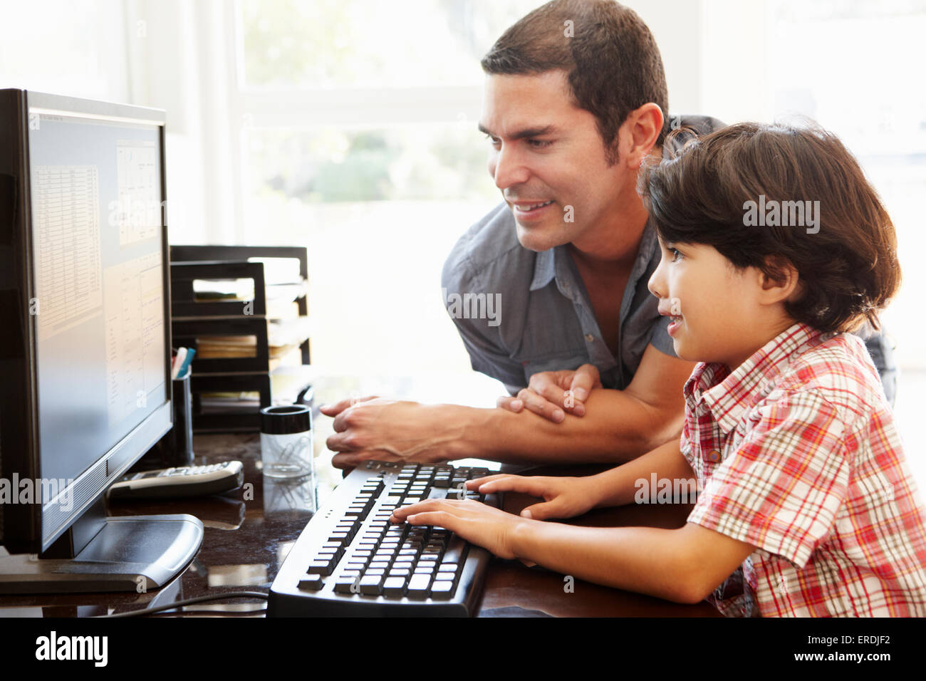 Hispanic father and son using computer at home Stock Photo - Alamy