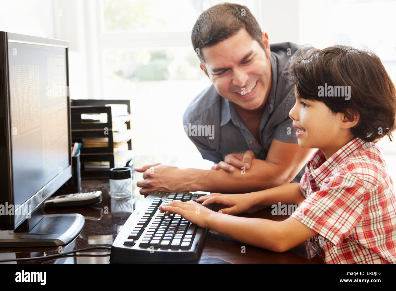 Hispanic father and son using computer at home Stock Photo - Alamy