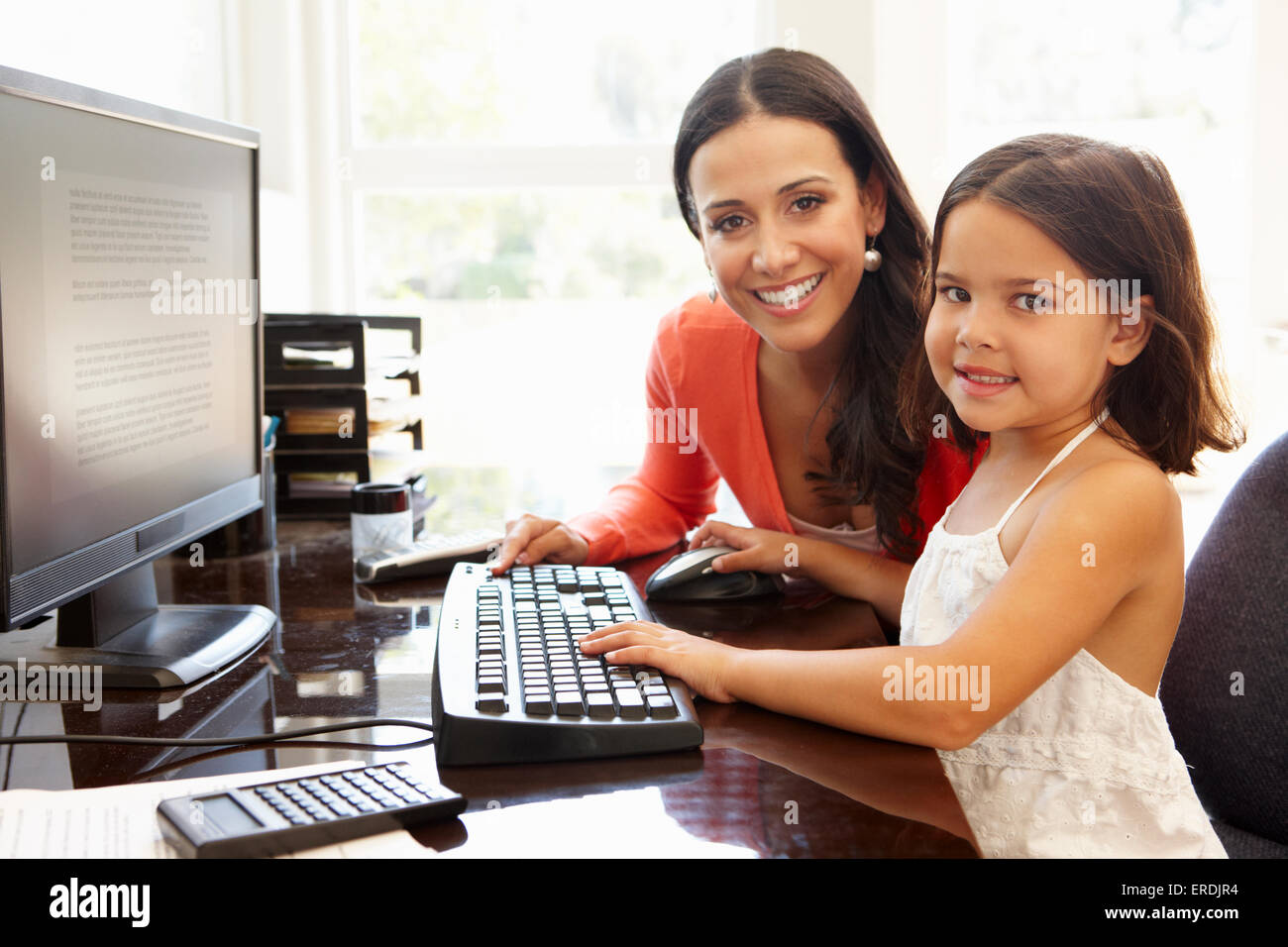 Hispanic mother and daughter using computer at home Stock Photo - Alamy