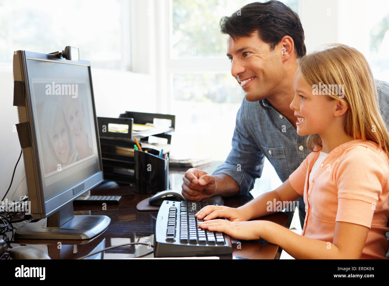 Father and daughter using skype in home office Stock Photo - Alamy