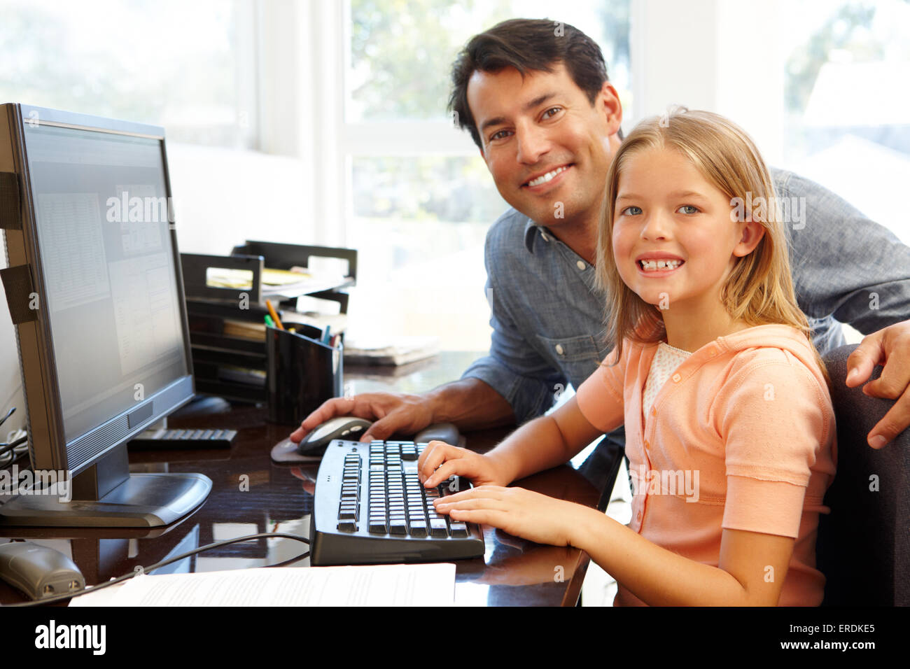 Father and daughter using computer in home office Stock Photo - Alamy