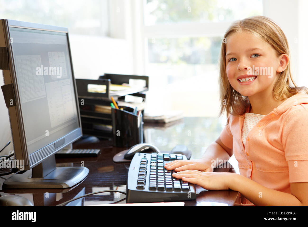 Young girl using computer at home Stock Photo - Alamy