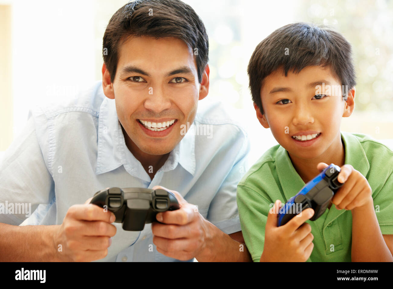 Asian father and son playing videogames Stock Photo - Alamy