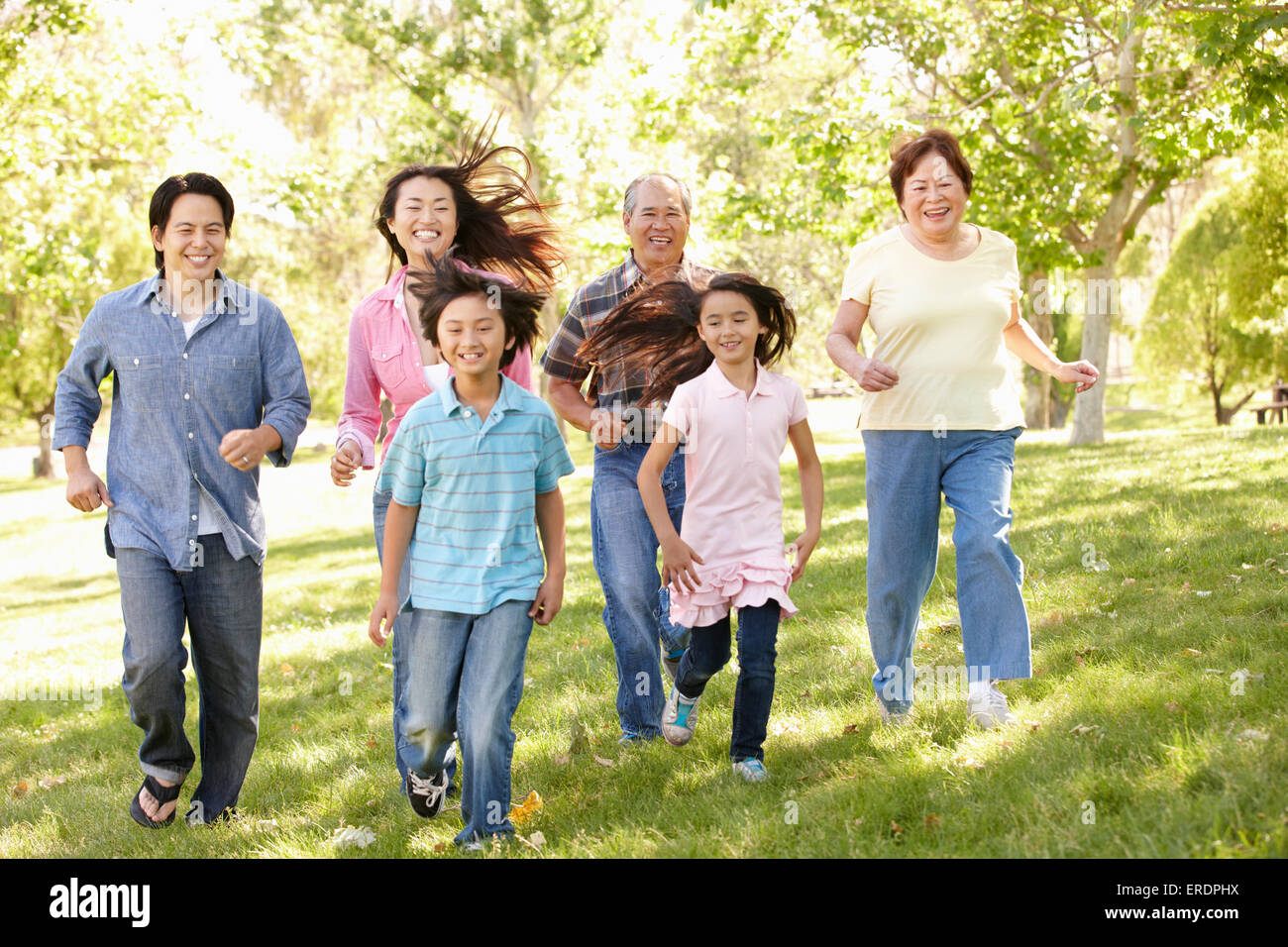 Multi-generation Asian family running in park Stock Photo - Alamy