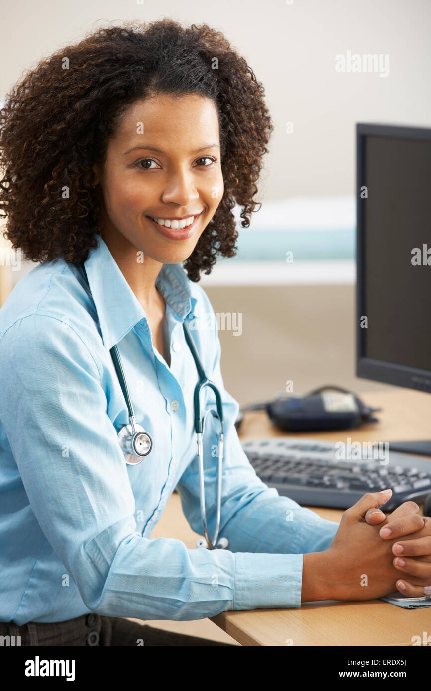 Young female Doctor sitting at desk Stock Photo - Alamy