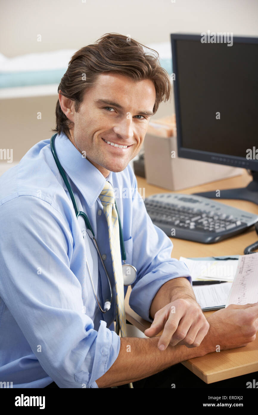 Doctor sitting at desk Stock Photo - Alamy
