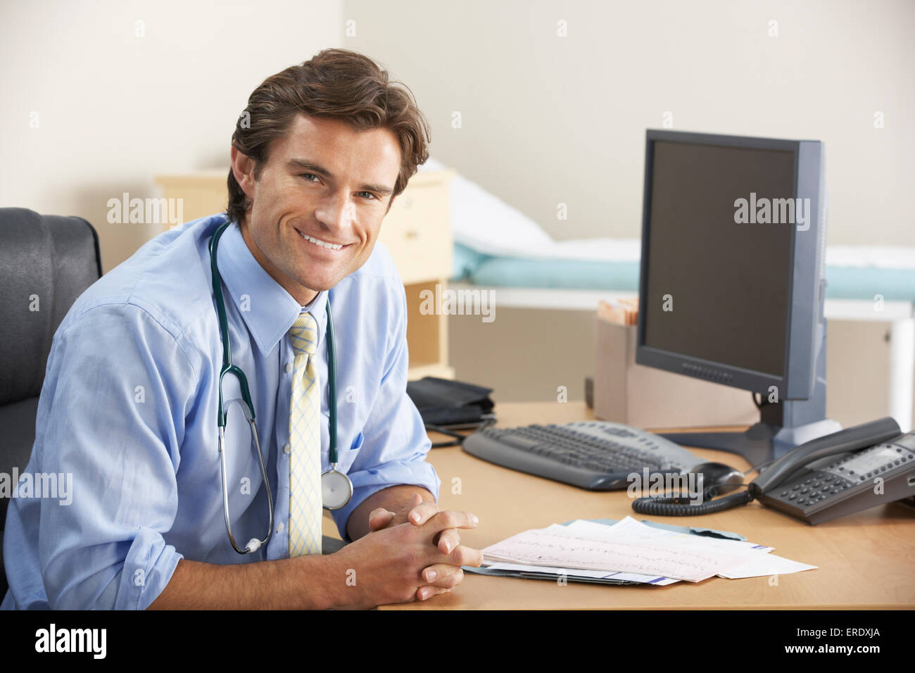 Doctor sitting at desk Stock Photo - Alamy