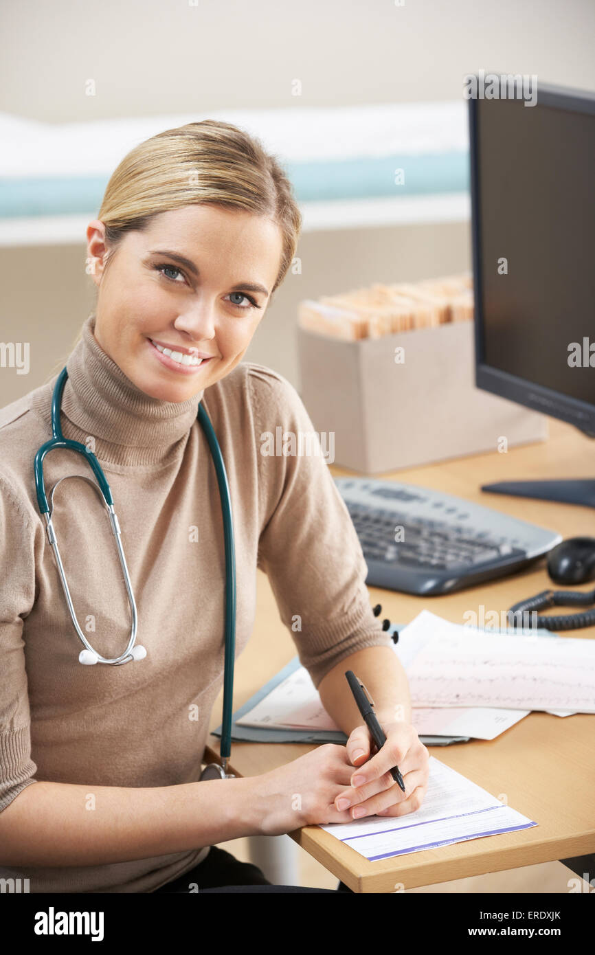 Female Doctor sitting at desk Stock Photo - Alamy